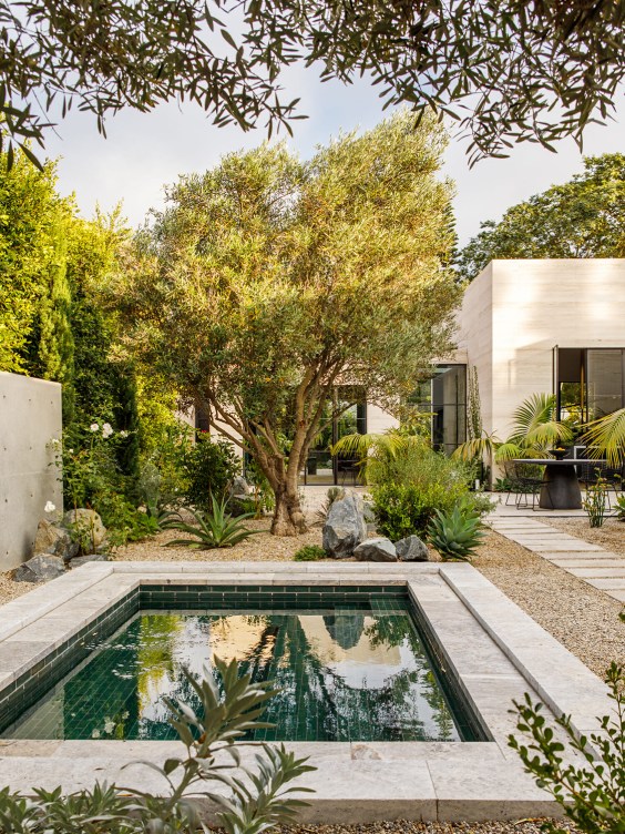 This Meandering Courtyard Spans a Travertine Shower and Green Tile Pool